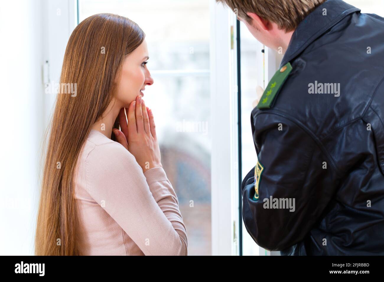 Police officer takes evidence on window after burglary in apartment ...