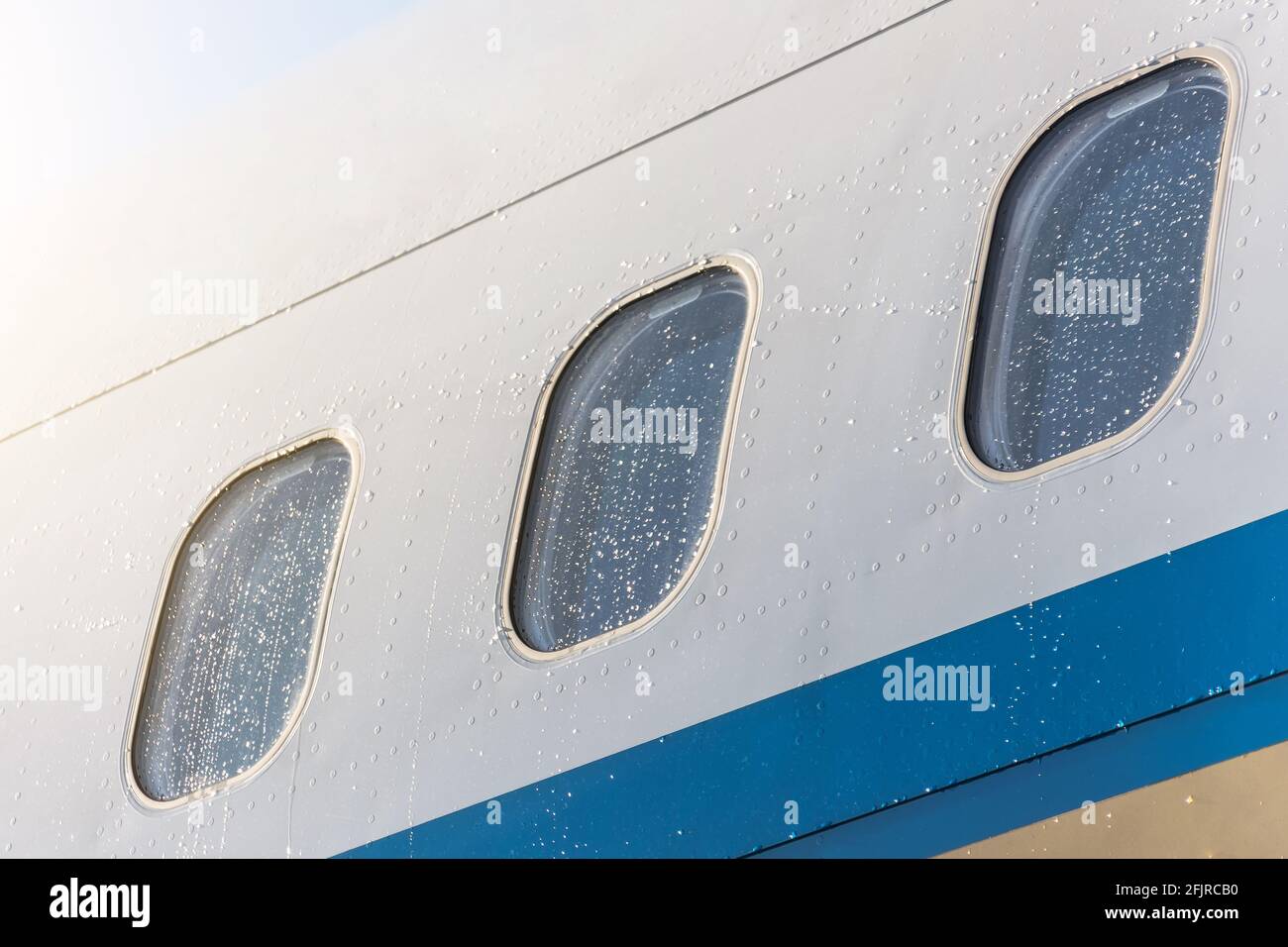 Porthole windows of an airplane wet weather in rain drops of water ...
