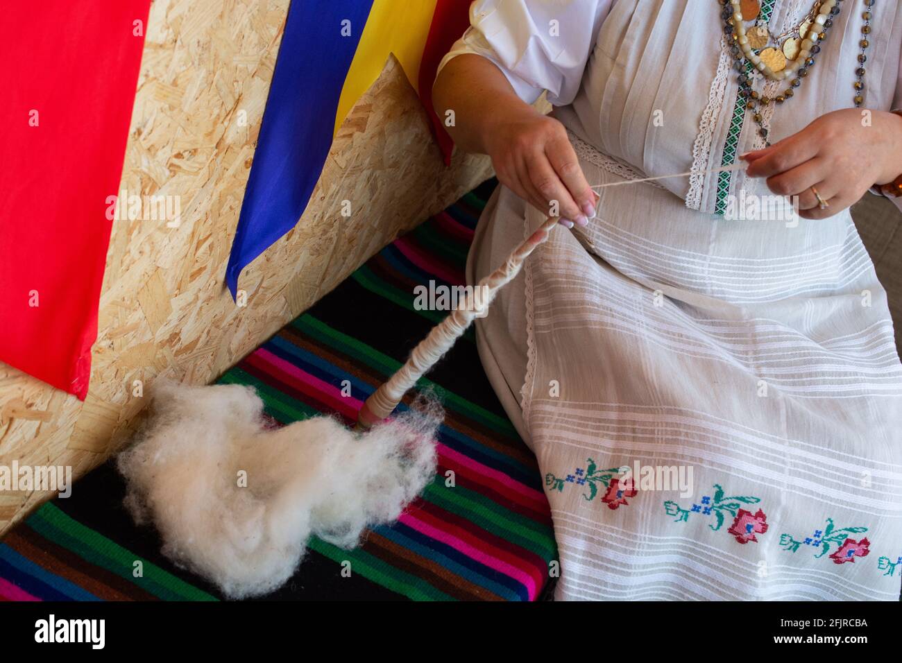 Spinner creates a thread of white wool. Creating yarn threads Stock ...