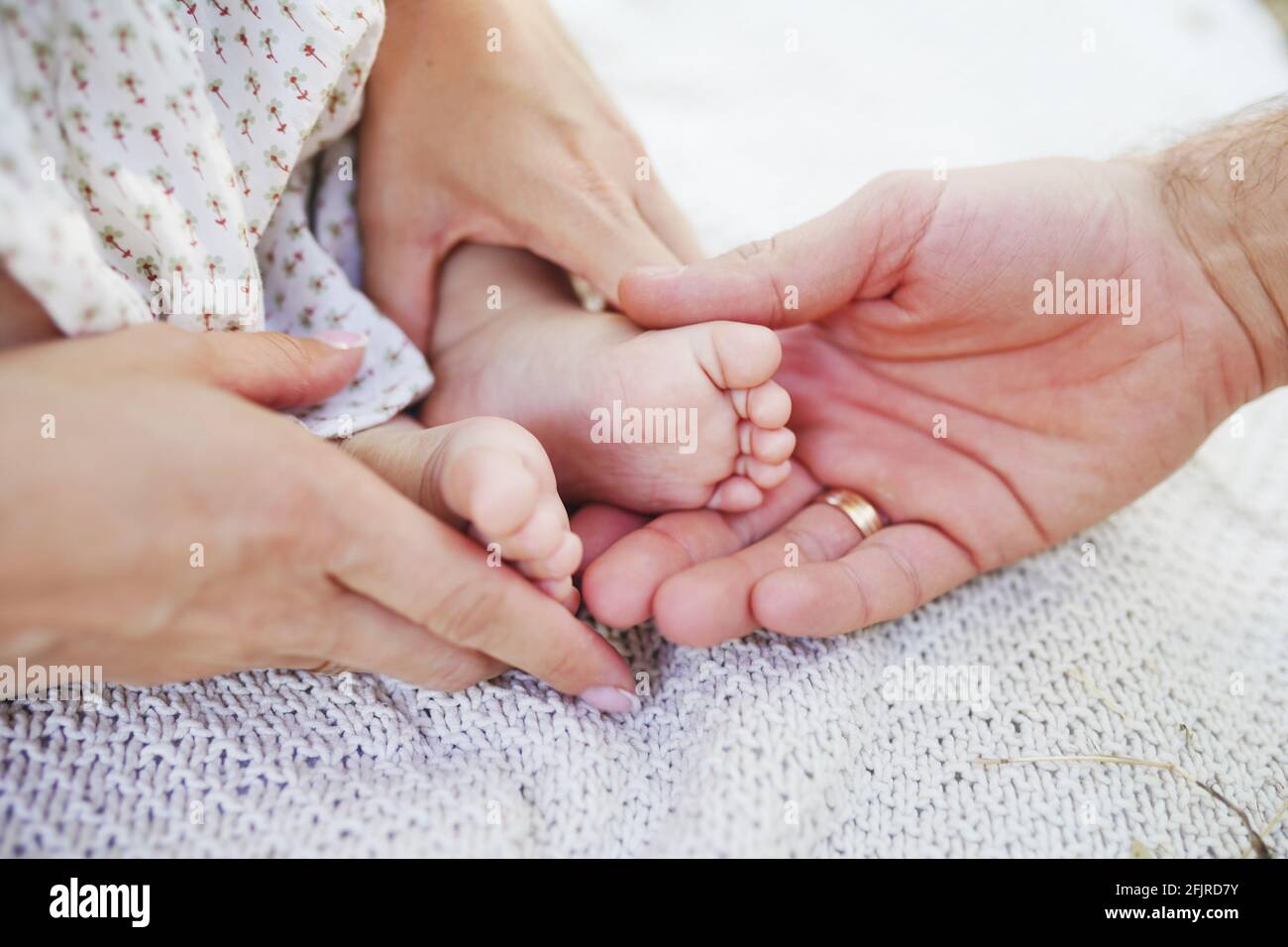 Newborn baby feet parents holding in hands. New born kind and Love ...