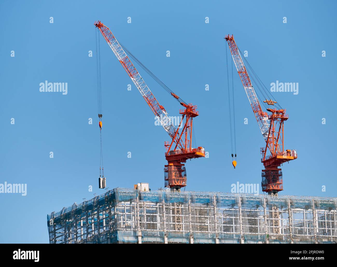 The view of the two cranes renewing the skyscraper top at the ...