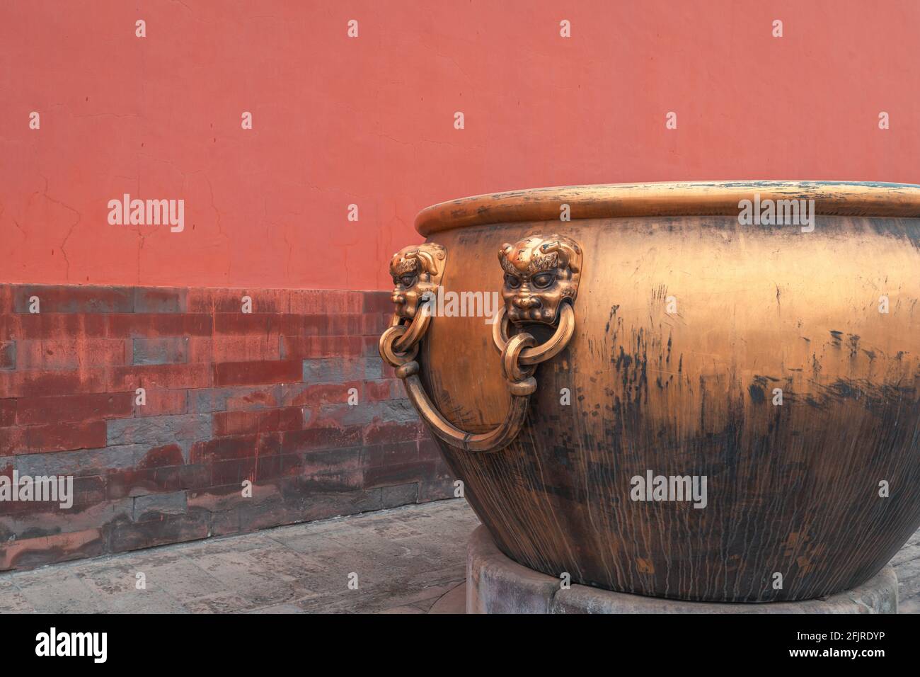 Golden water tank with lion statue against red wall in the Forbidden ...