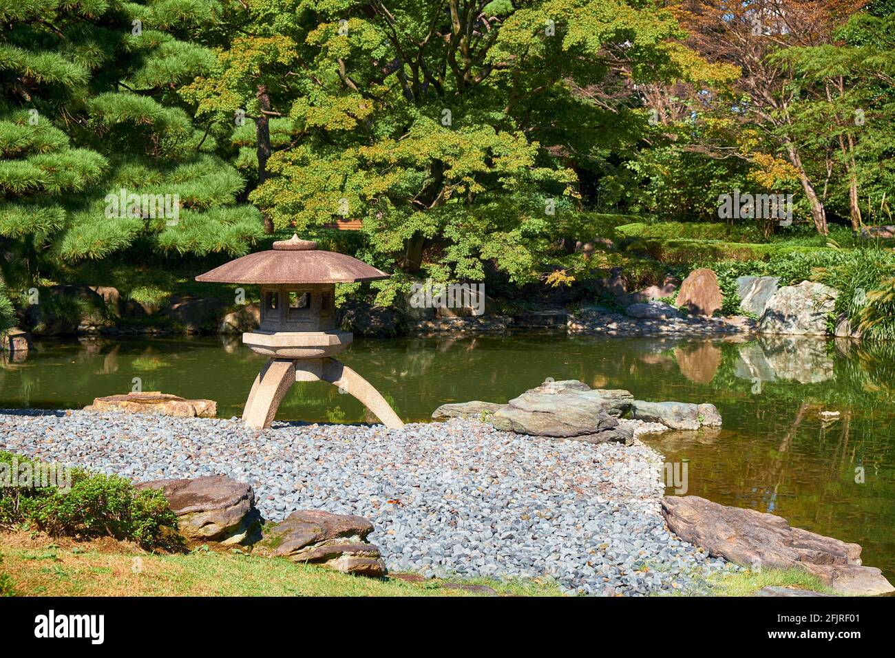 Yukimi-doro stone toro lantern near the water of pond at the Ninomaru ...