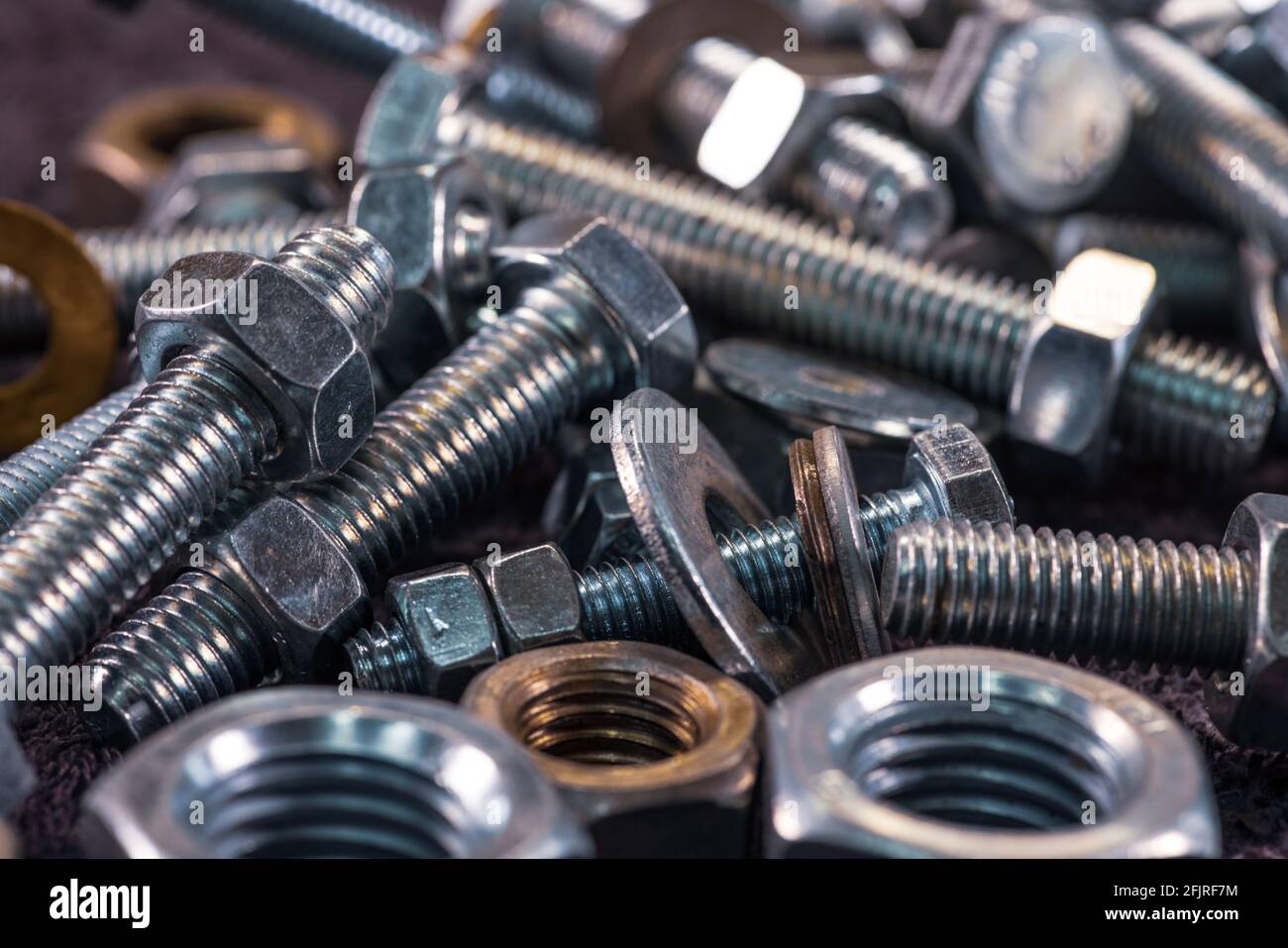 Close-up metal chrome bolts and nuts in a chaotic order. Background ...