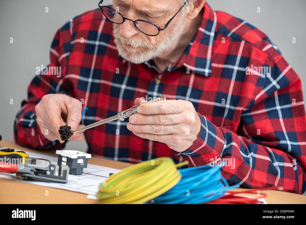 Senior electrician connecting wires in terminal block Stock Photo - Alamy