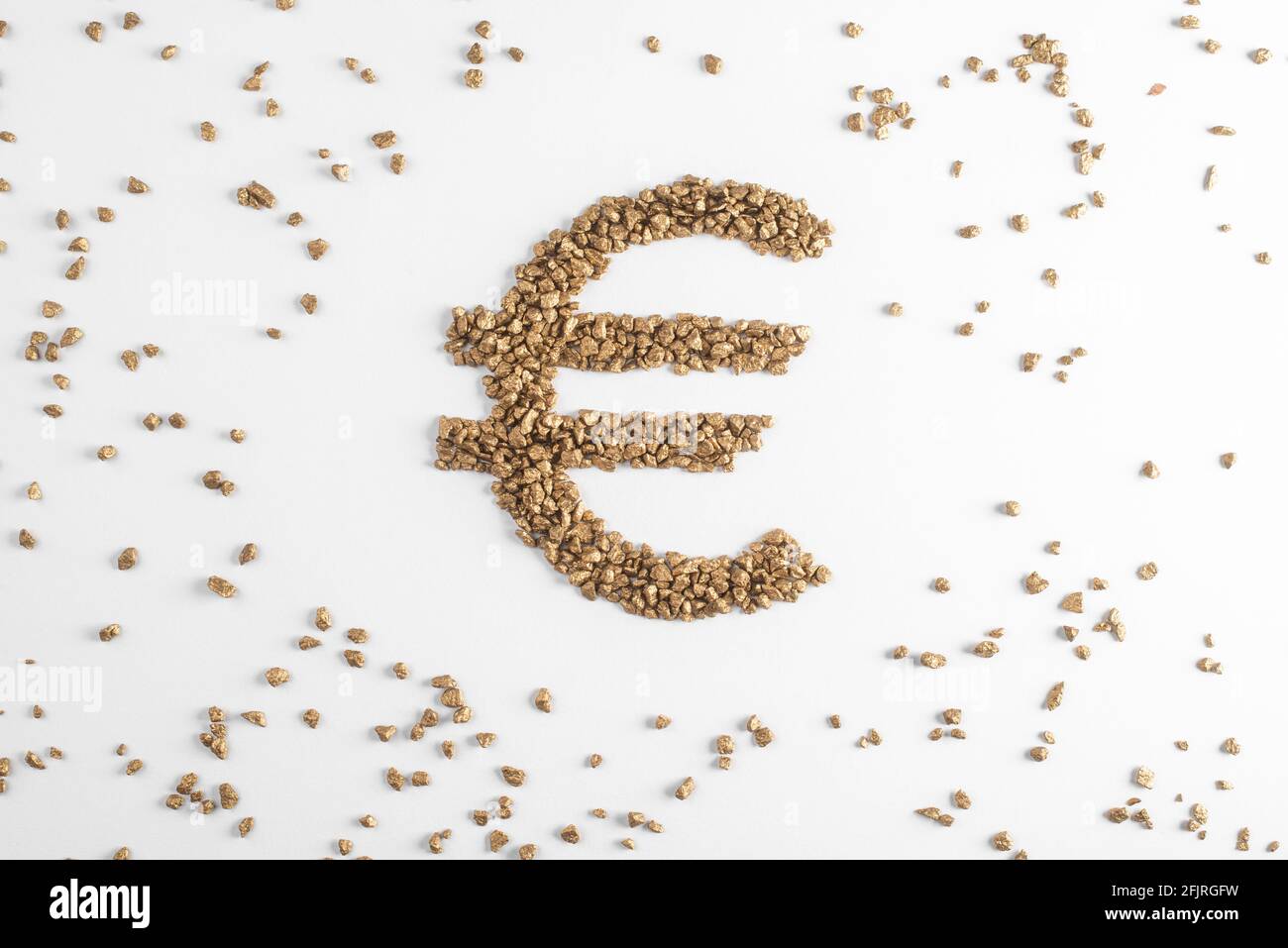 Golden euro sign surrounded with scattered pieces of gold on white ...