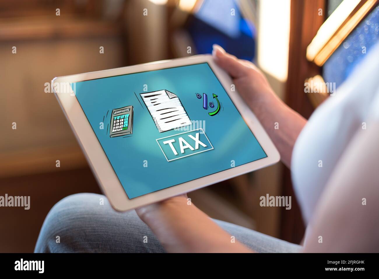 Woman holding a tablet showing tax concept Stock Photo - Alamy