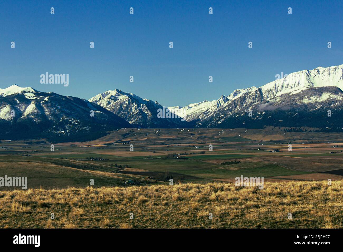 Scenic shot of beautiful landscape field below the snowy Wallowa ...