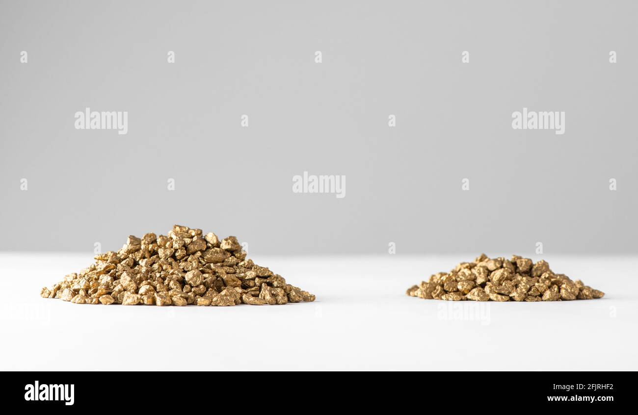 Two heaps of golden nuggets on white background Stock Photo - Alamy