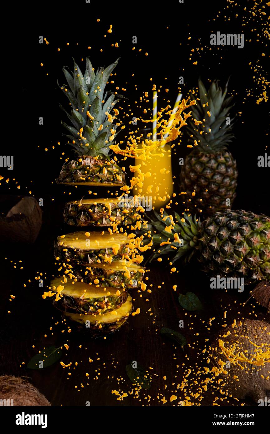 Pineapple flying in air cut in slices with juice splash Stock Photo - Alamy