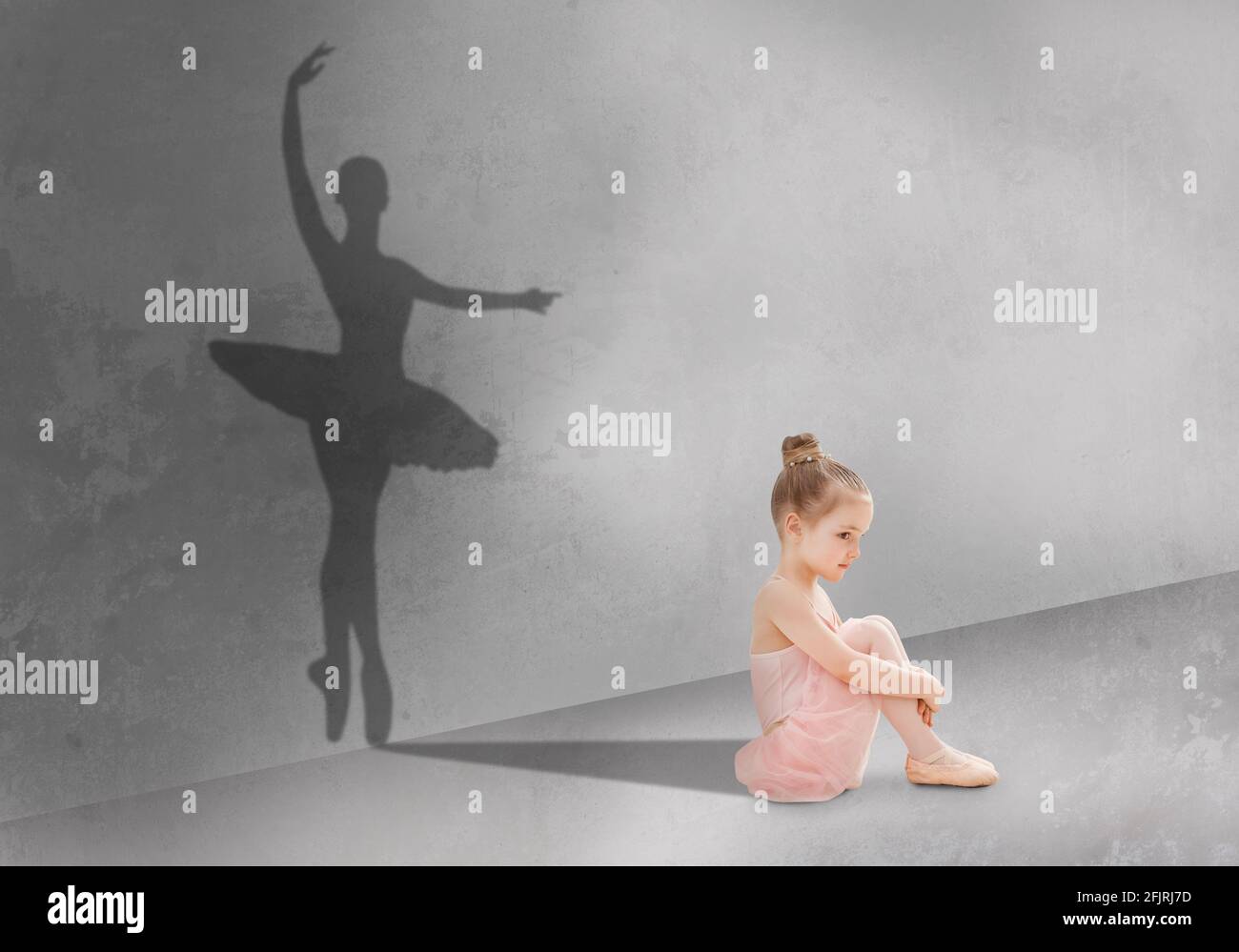 Cute little girl sitting on floor in dance studio, shadow of ballet ...