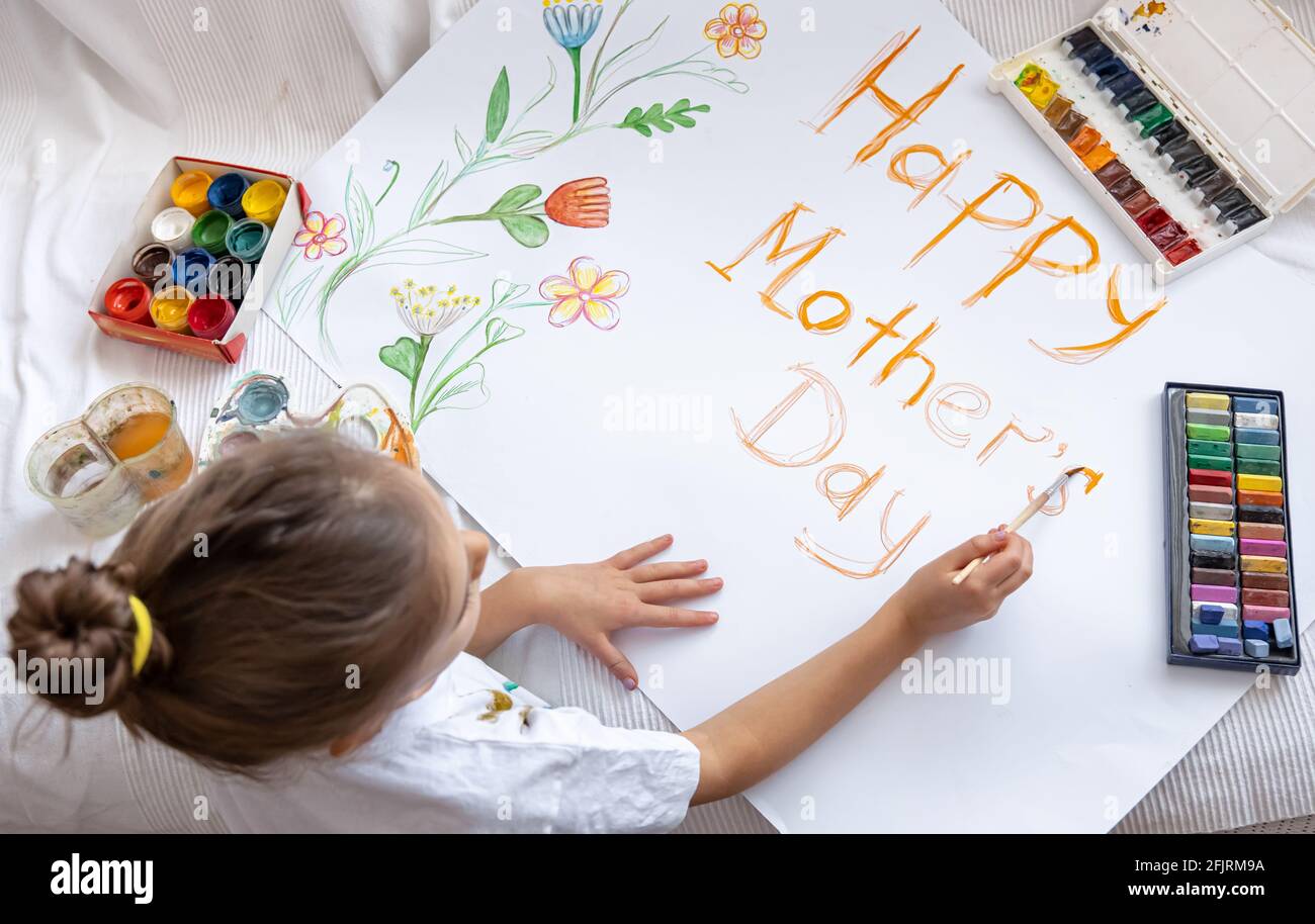 Little girl paints with paints and crayons greeting card for Mom on ...