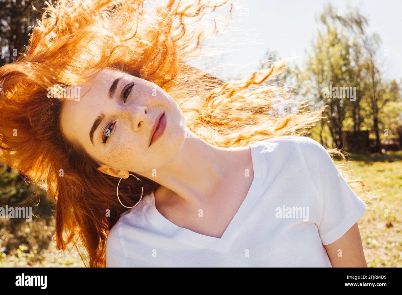 Young happy woman with flying long curly hair in sunshine Stock Photo ...