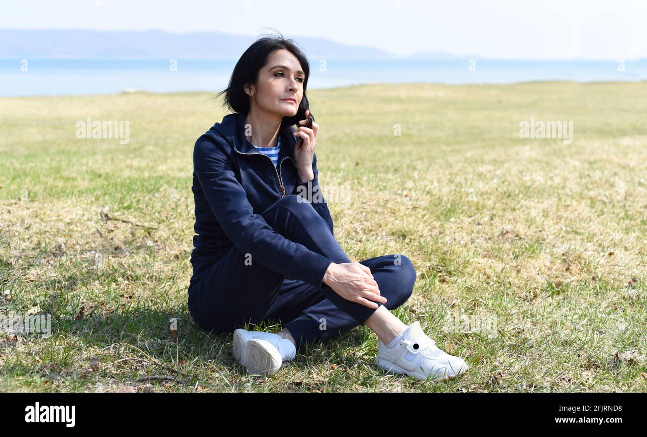 45 y.o. Russian woman sitting and enjoying nature at the beach of ...