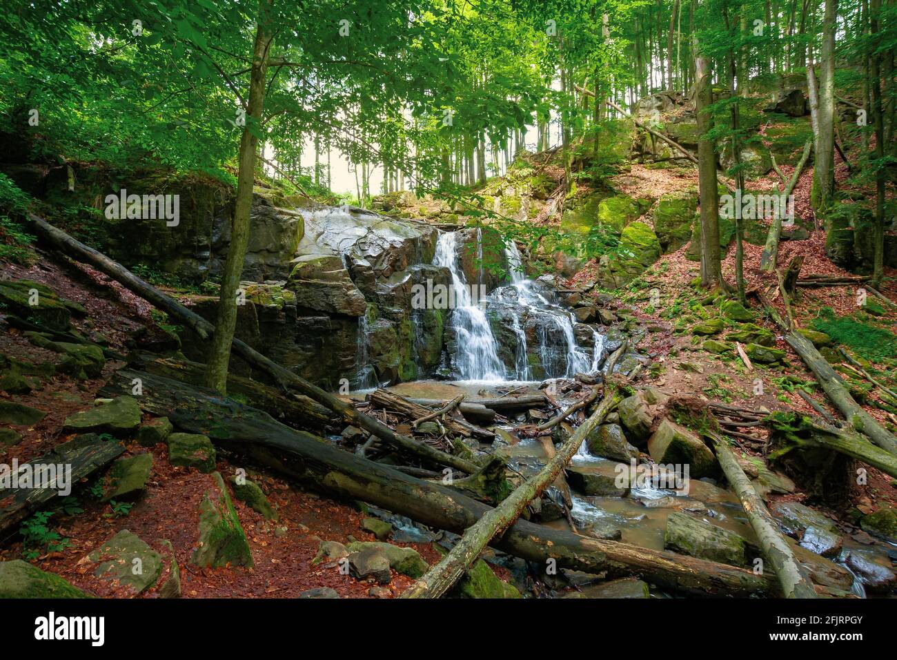 landscape with waterfall in spring. powerful water flow comes out of ...
