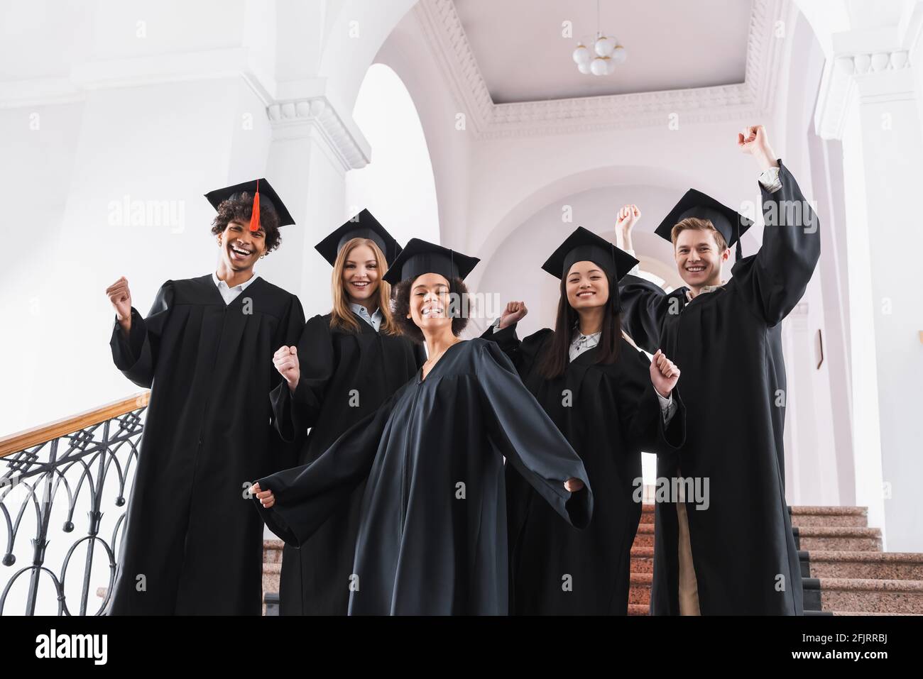 Students in graduation hall in caps and gowns hi-res stock photography ...