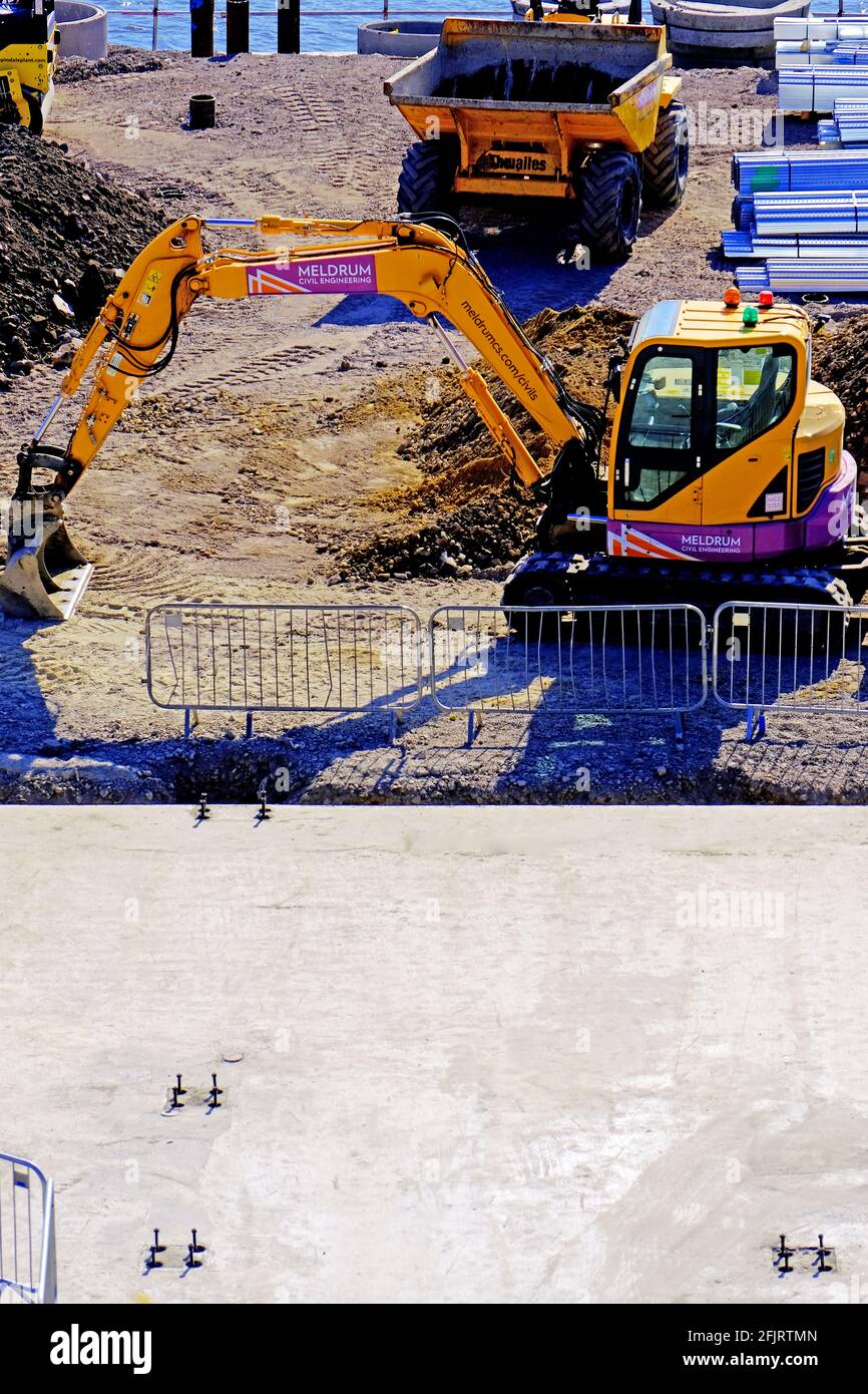 Caterpillar digger working on concrete foundations for riverside ...