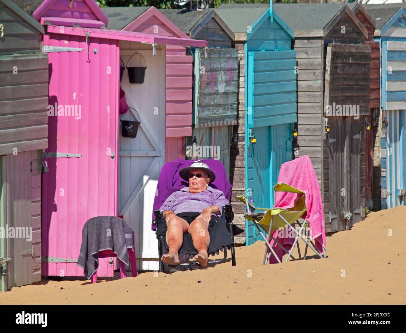 A lady sunbathes outside her beach hut in Broadstairs, Kent Stock Photo ...
