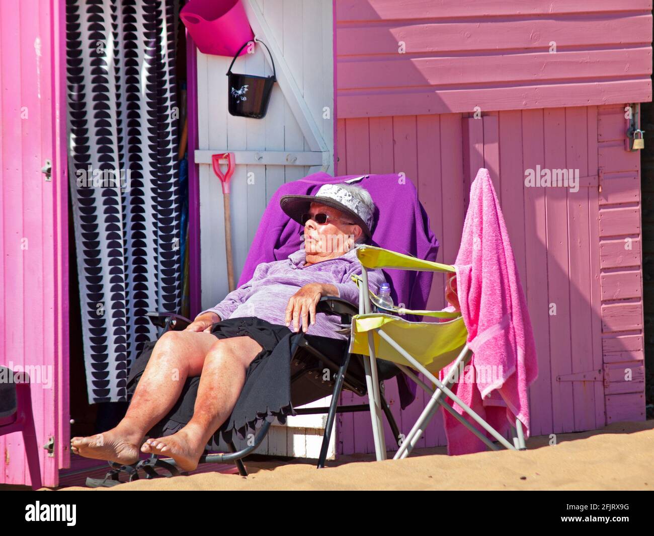 A lady sunbathes outside her beach hut in Broadstairs, Kent Stock Photo ...