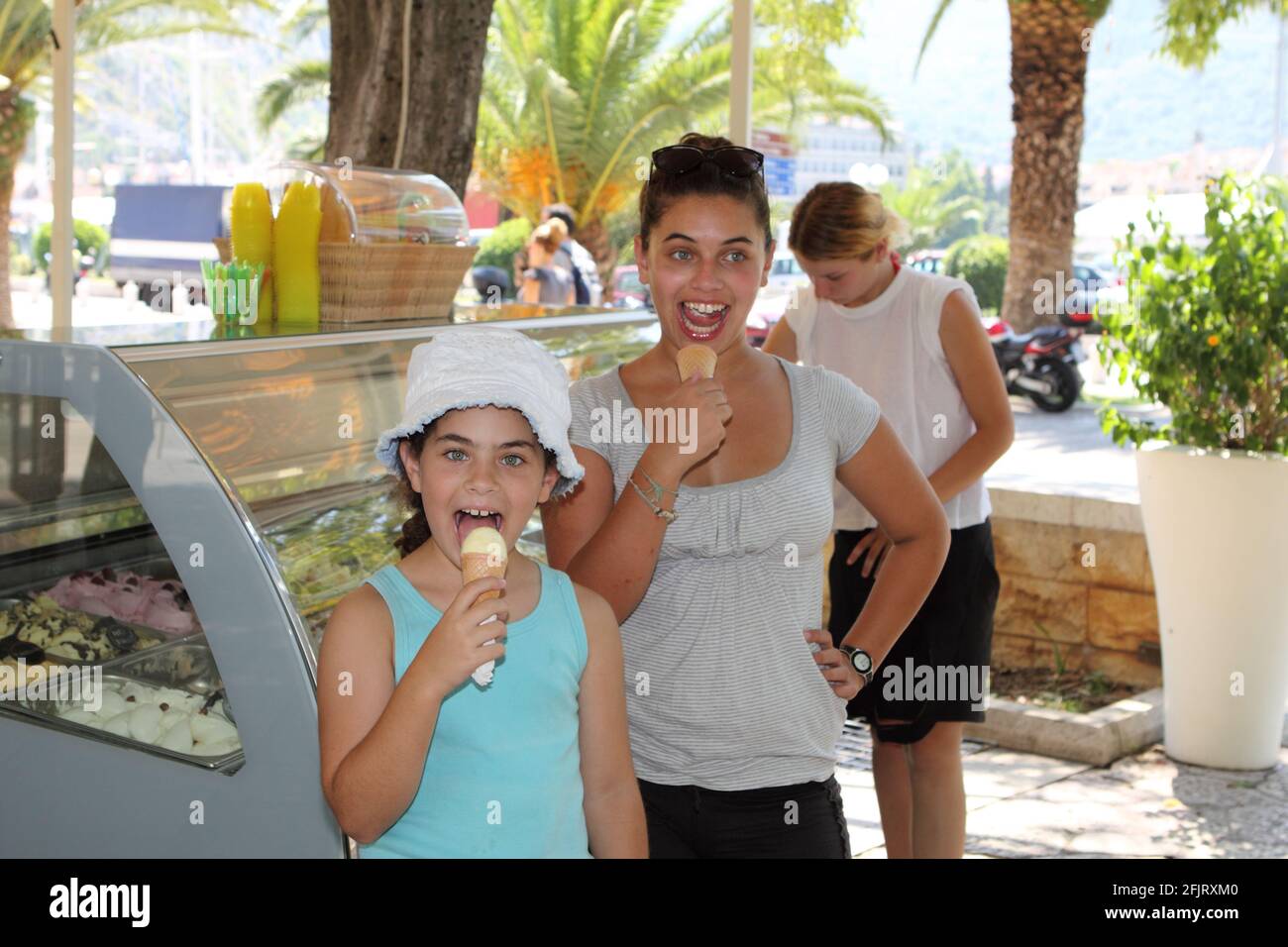 Sisters eat ice cream, smile, both of them make eyes, Kotor, Montenegro ...
