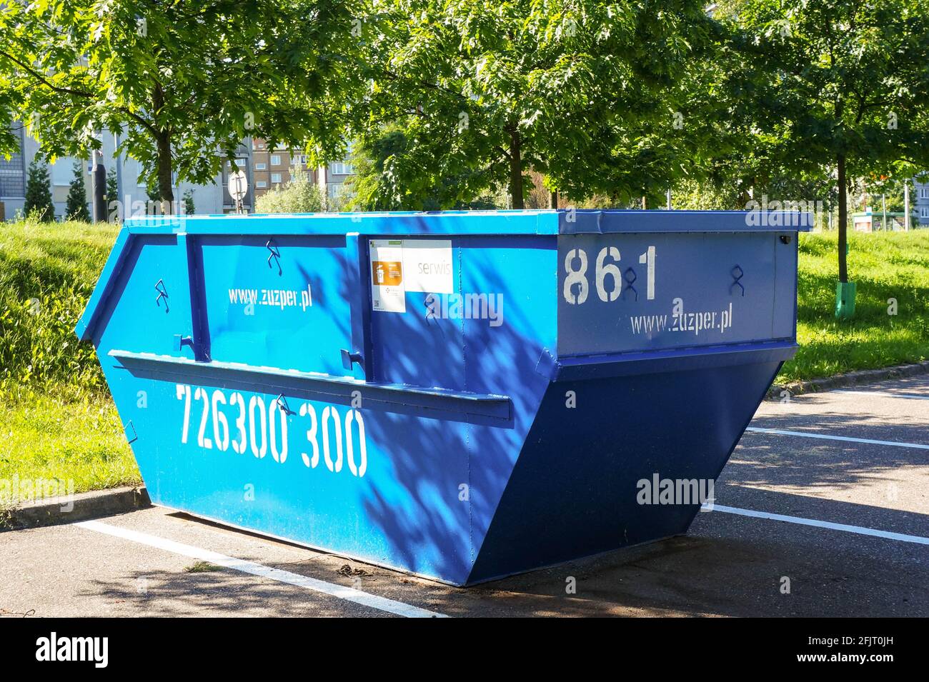 POZNAN, POLAND - Sep 20, 2015: Blue trash container on a parking lot ...