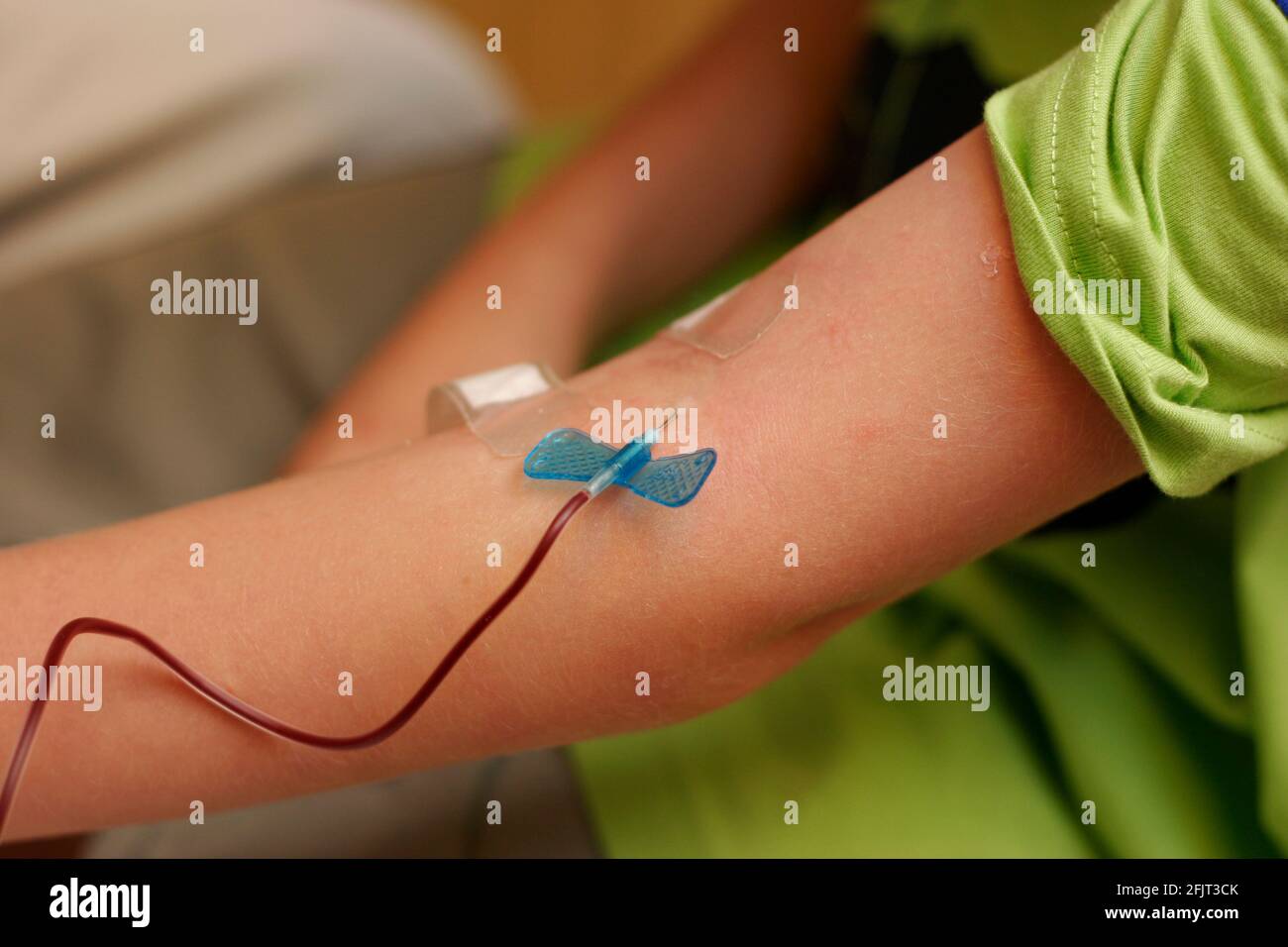 Young boy of six having blood drawn from his arm for a bone marrow test ...