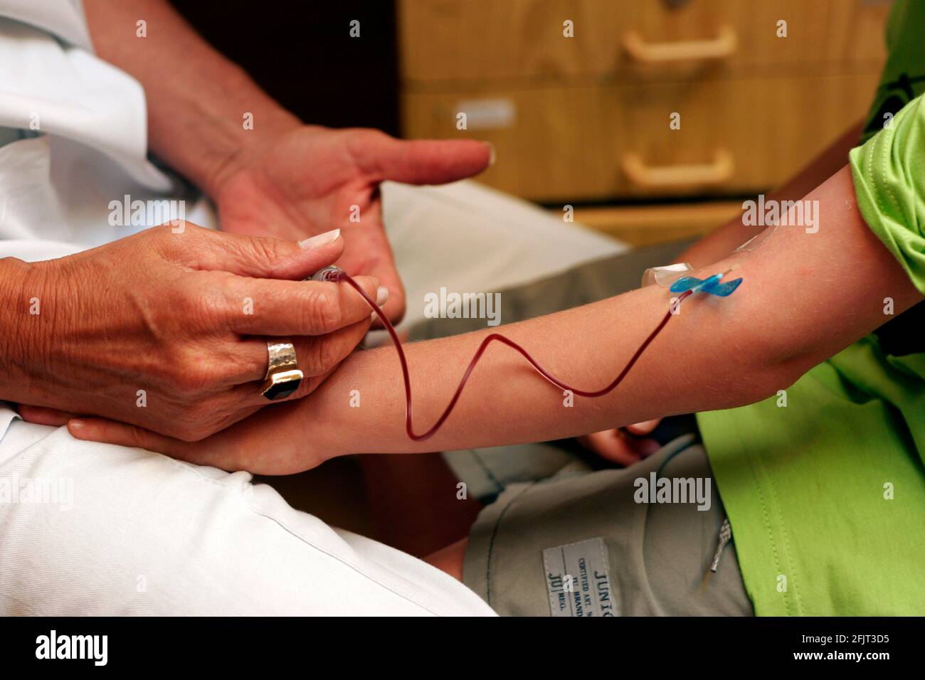 Young boy of six having blood drawn from his arm for a bone marrow test ...
