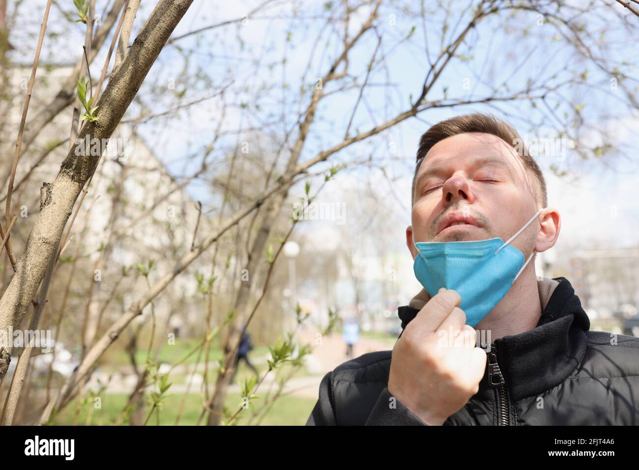 Man walking in park and taking off protective mask from his face Stock ...