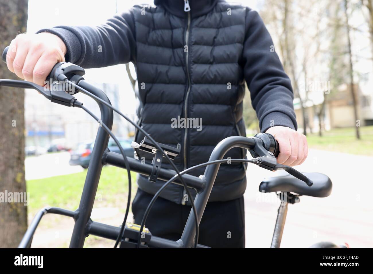 Man holding wheel of bicycle outdoors closeup Stock Photo - Alamy
