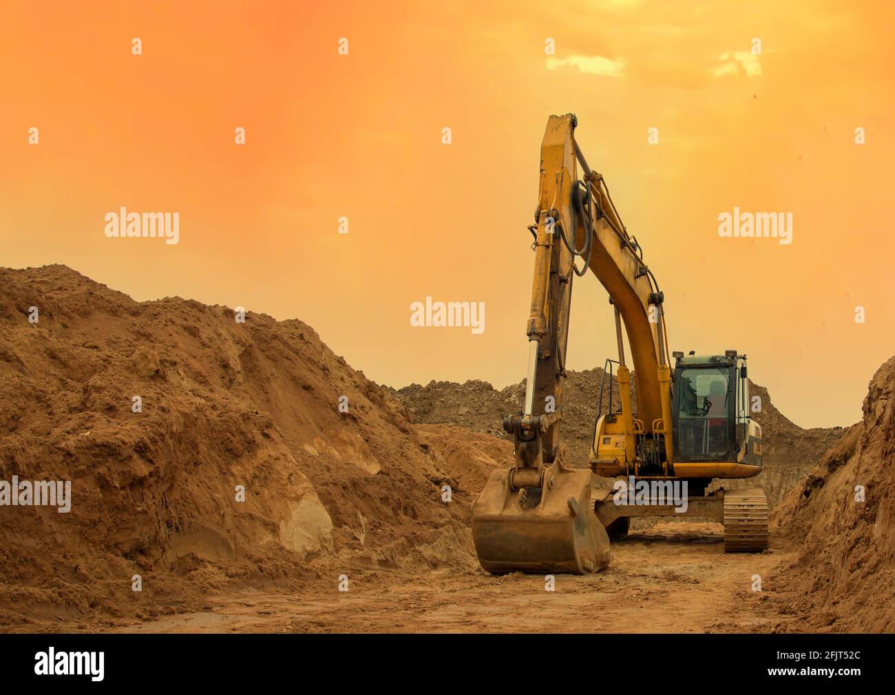 Excavator working on earthmoving at open pit mining on amazing sunset ...