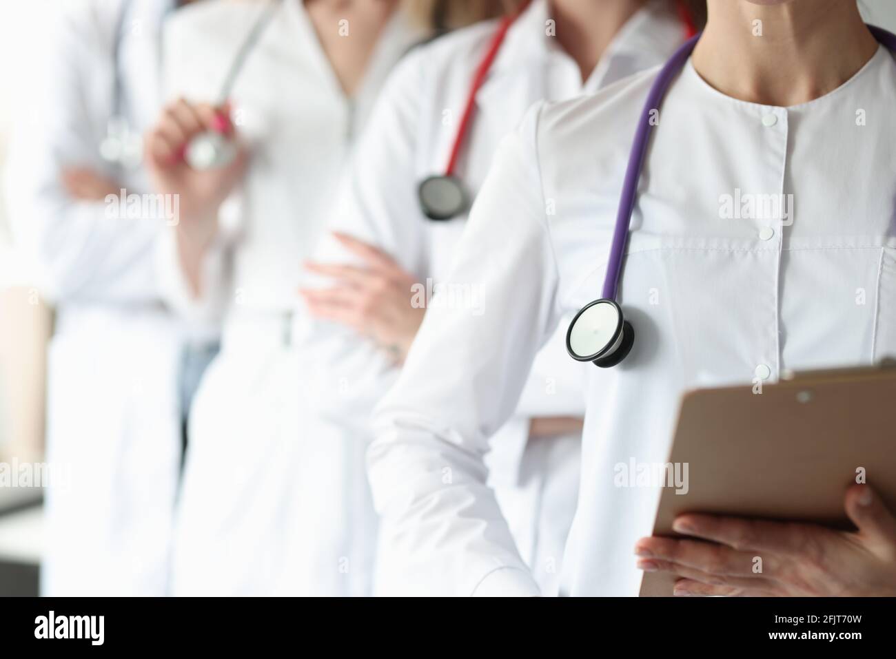 Group of doctors with stethoscope around their neck stands in clinic ...