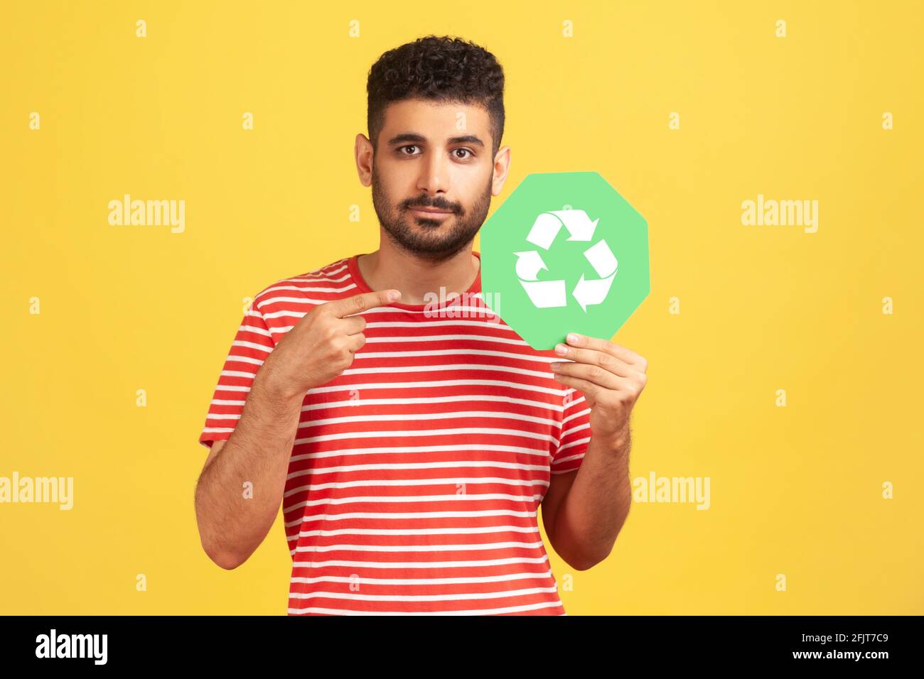 Serious bearded man in red t-shirt pointing finger at waste recycling ...