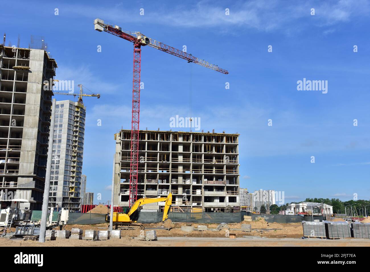 Tower cranes in action on blue sky background. Excavator dig ground for ...
