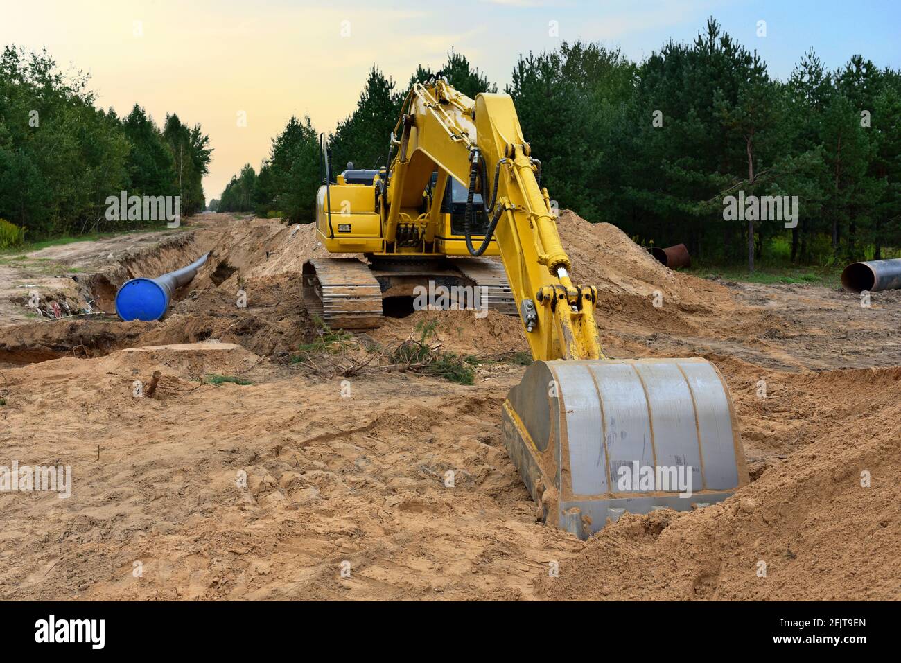 Excavator during earthwork for laying Crude oil and Natural gas ...