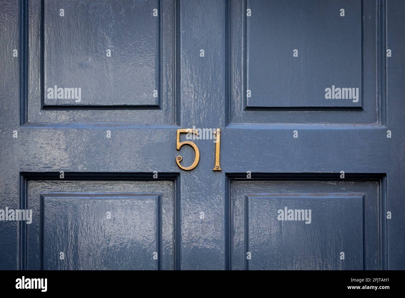 House number 51 on a blue wooden front door in golden metal digits ...
