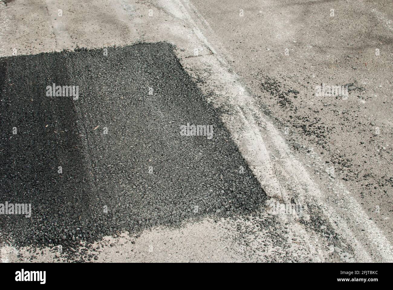 Cracked asphalt road surface and repair patch closeup Stock Photo - Alamy