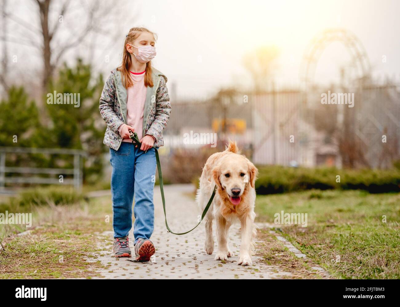 Little girl in mask with golden retriever dog Stock Photo - Alamy