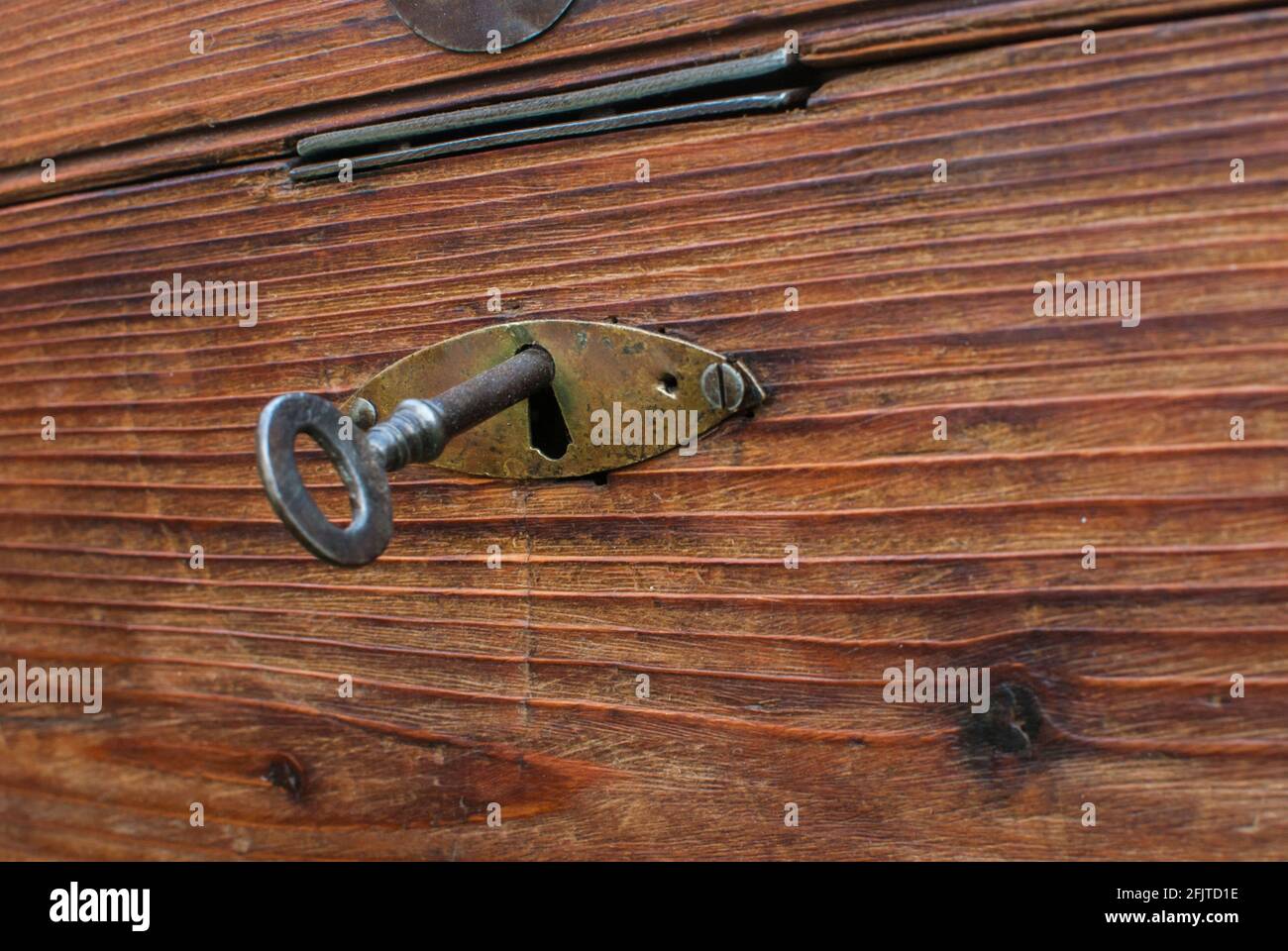 Vintage key in keyhole of retro wooden chest closeup Stock Photo - Alamy
