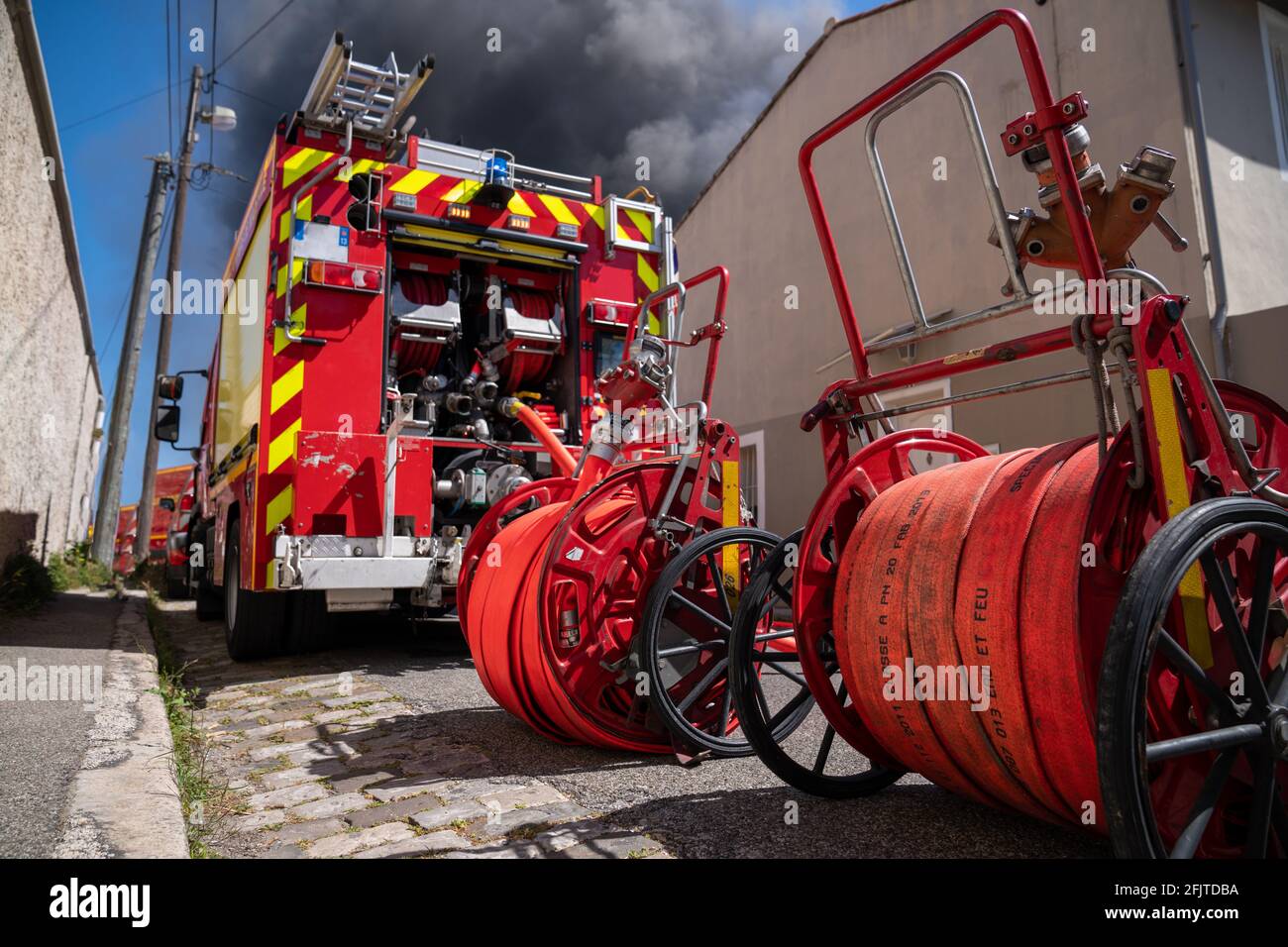 Red Firefighter engine and firefighter putting out huge fire Stock ...