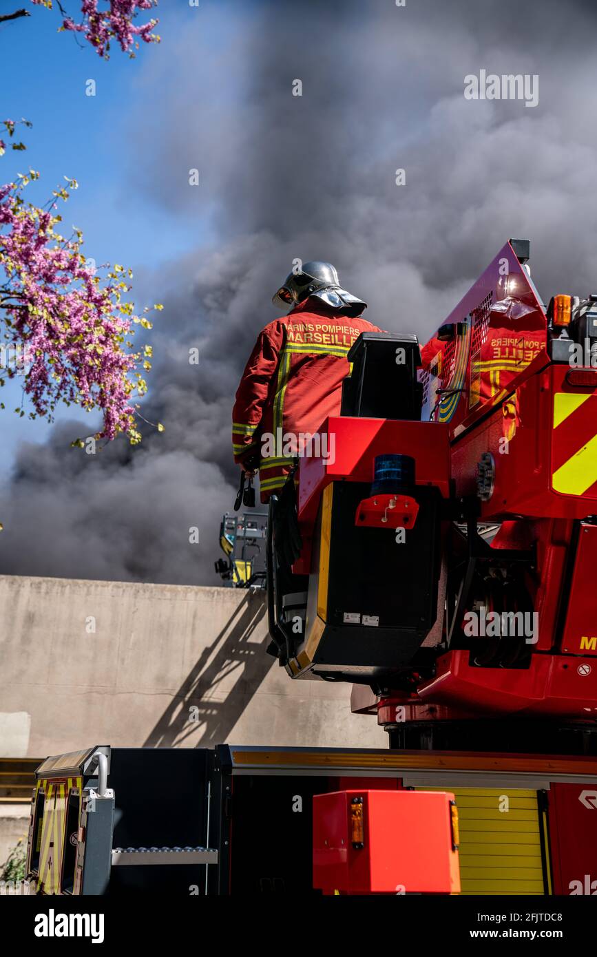 Red Firefighter engine and firefighter putting out huge fire Stock ...