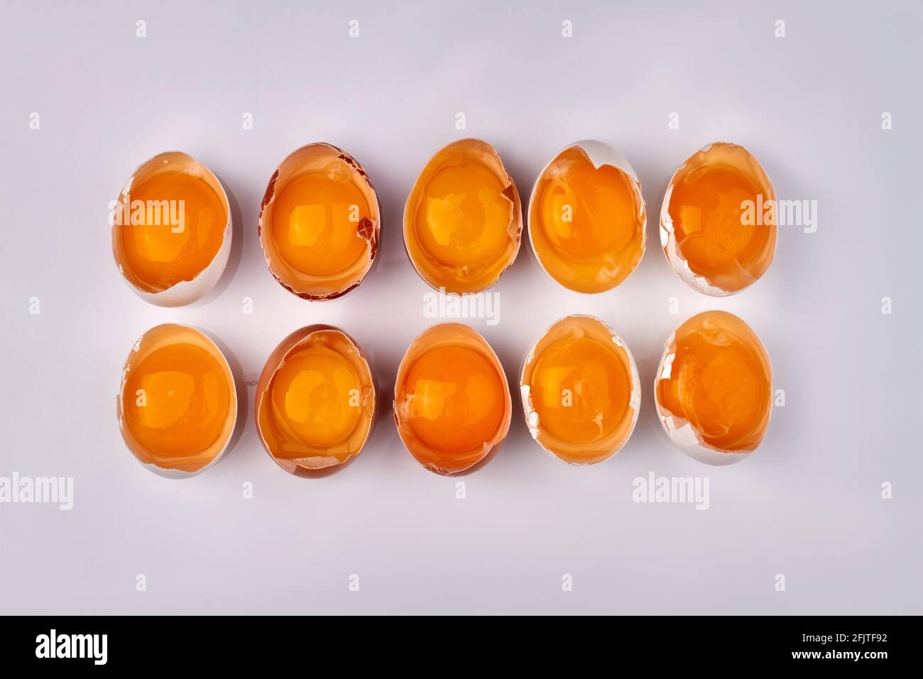 Half broken chicken eggs on white background Stock Photo - Alamy