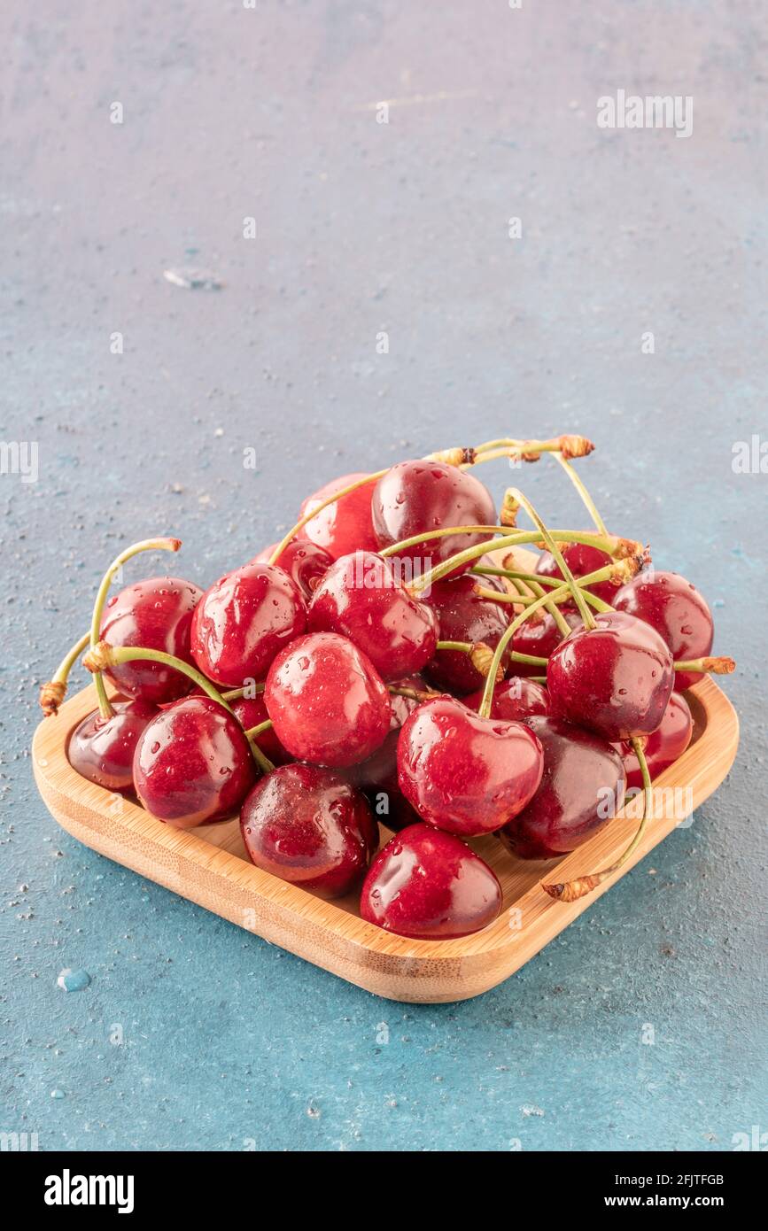 closeup fresh and ripe cherry fruits in a plate on table with copy ...