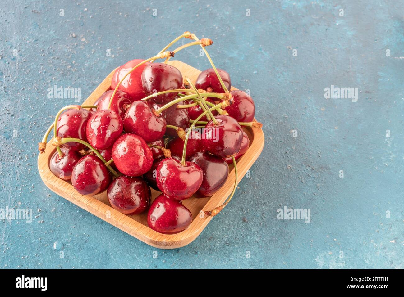 closeup fresh and ripe cherry fruits in a plate on table with copy ...