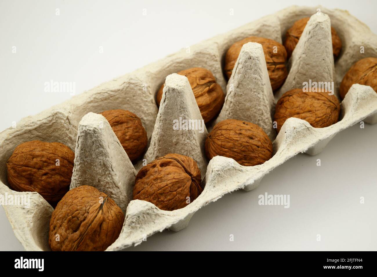 ten walnuts in a carton box on a white background Stock Photo - Alamy