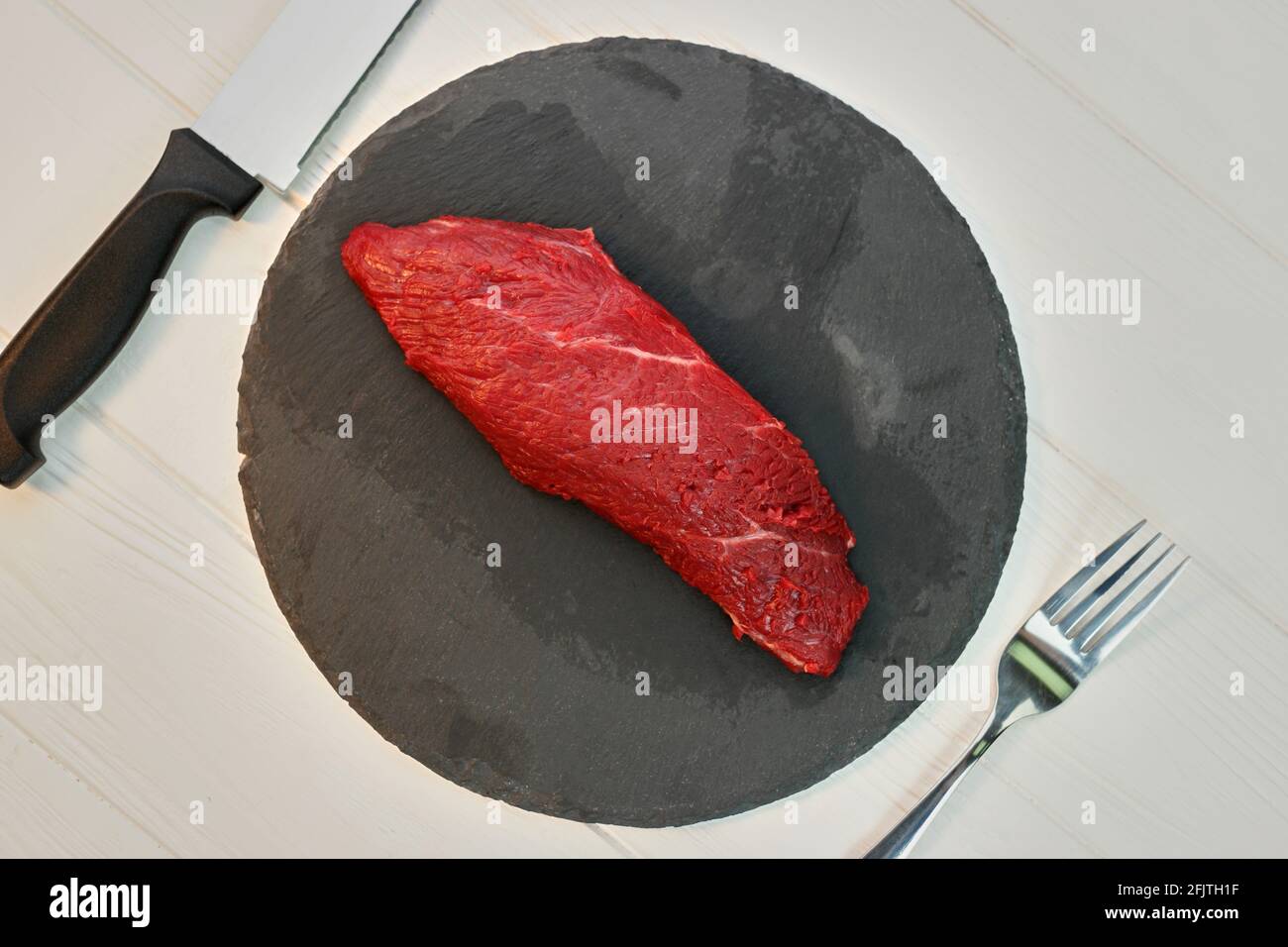 Raw edible veal meat on a plate, top view Stock Photo - Alamy