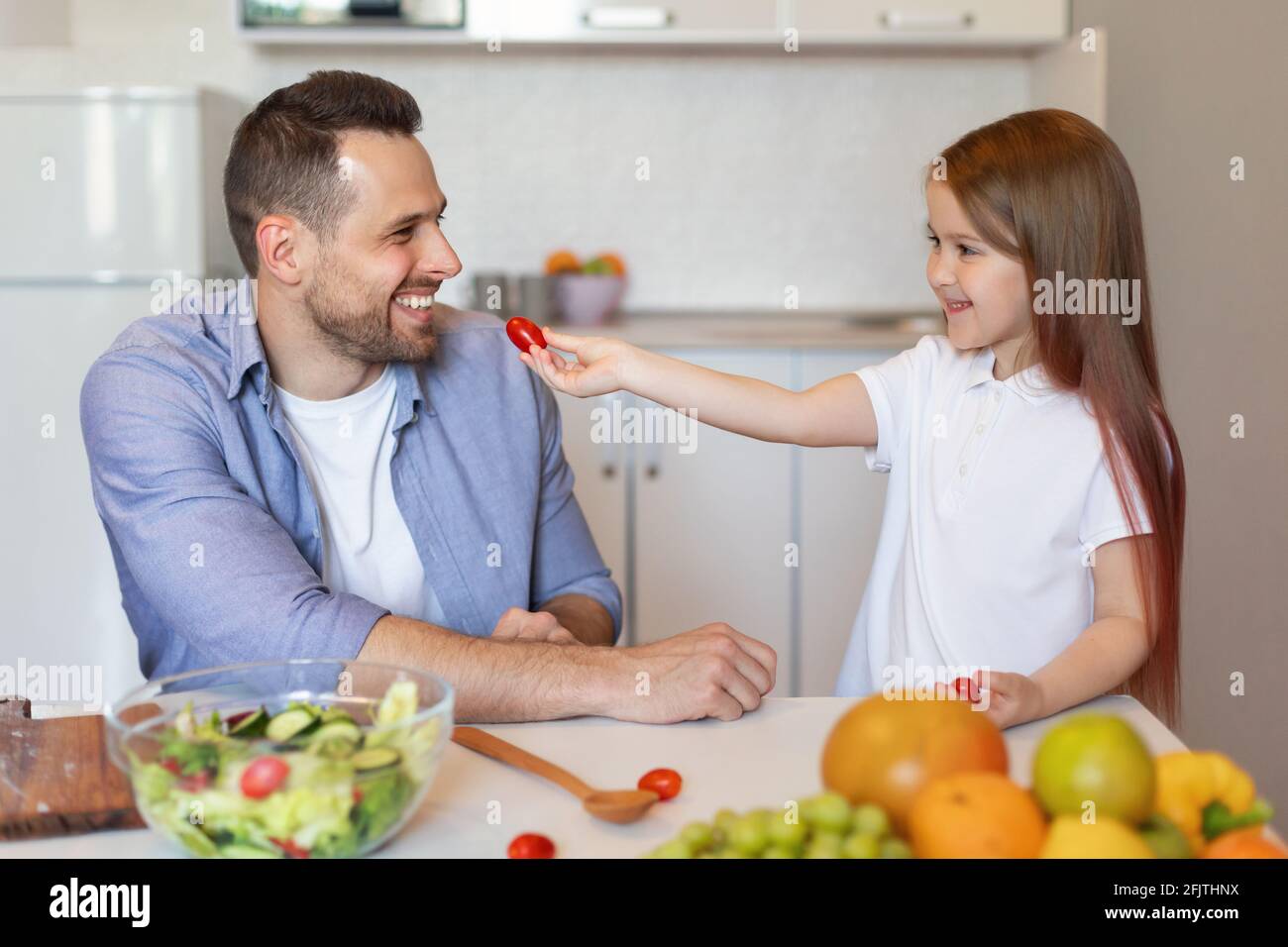Daughter Feeding Daddy Having Fun Cooking Together In Modern Kitchen ...