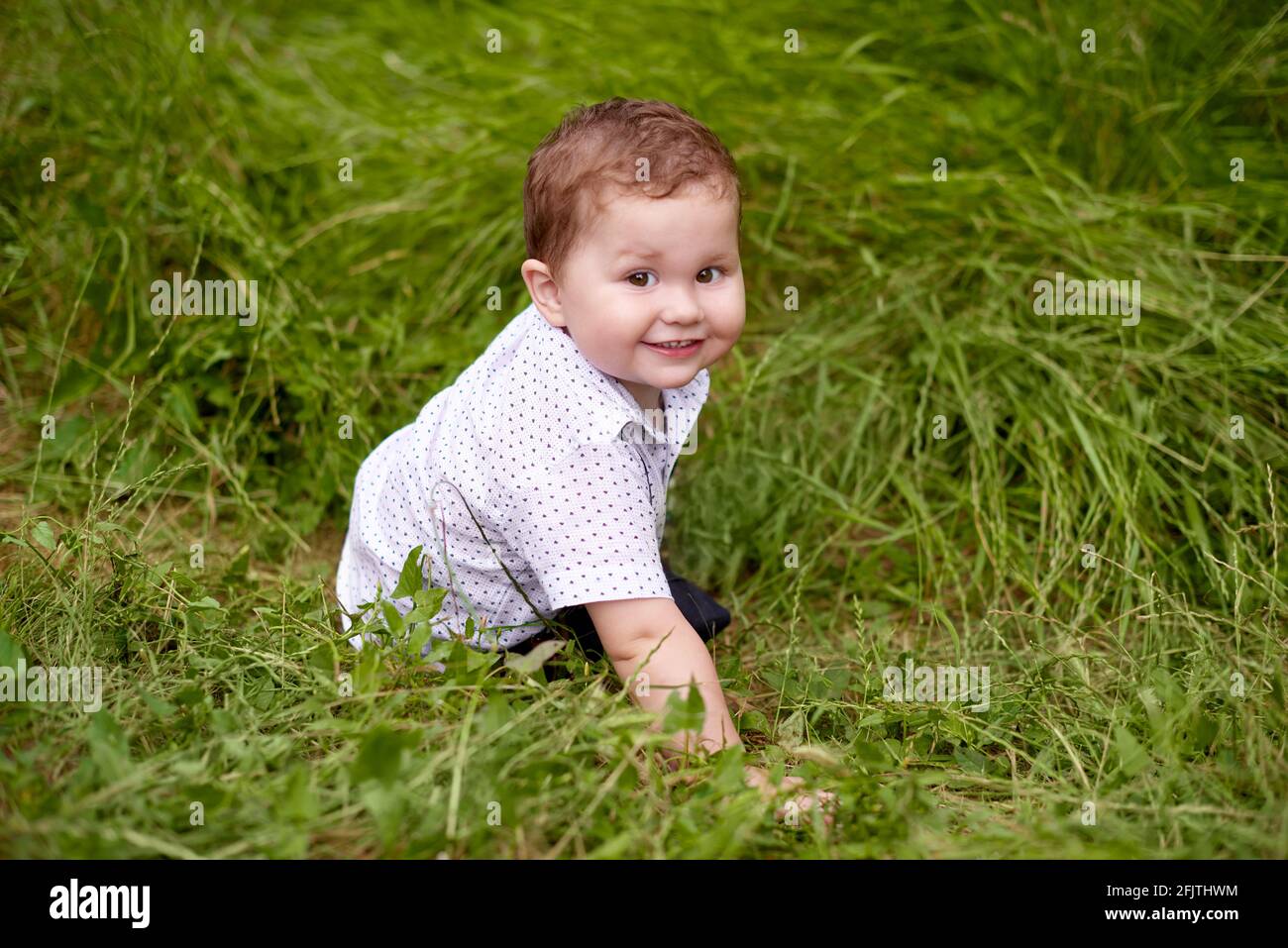 little boy playing in green grass. world children day content Stock ...