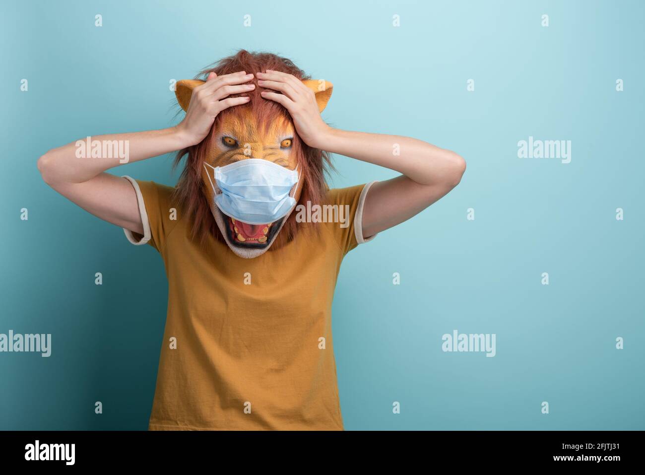 Young woman wearing lion and protection medical mask, shocked ...