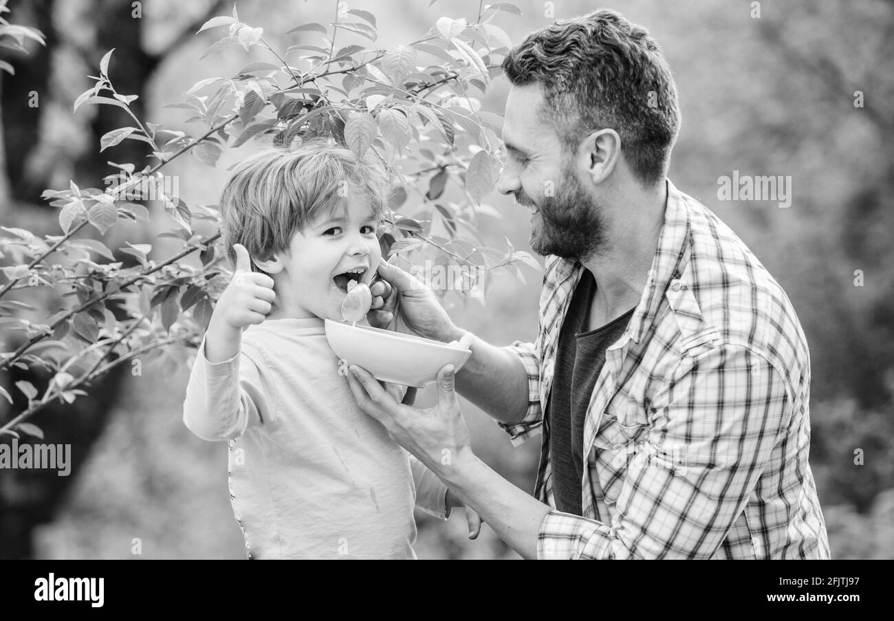 son and father eating outdoor. Morning breakfast. healthy food and ...