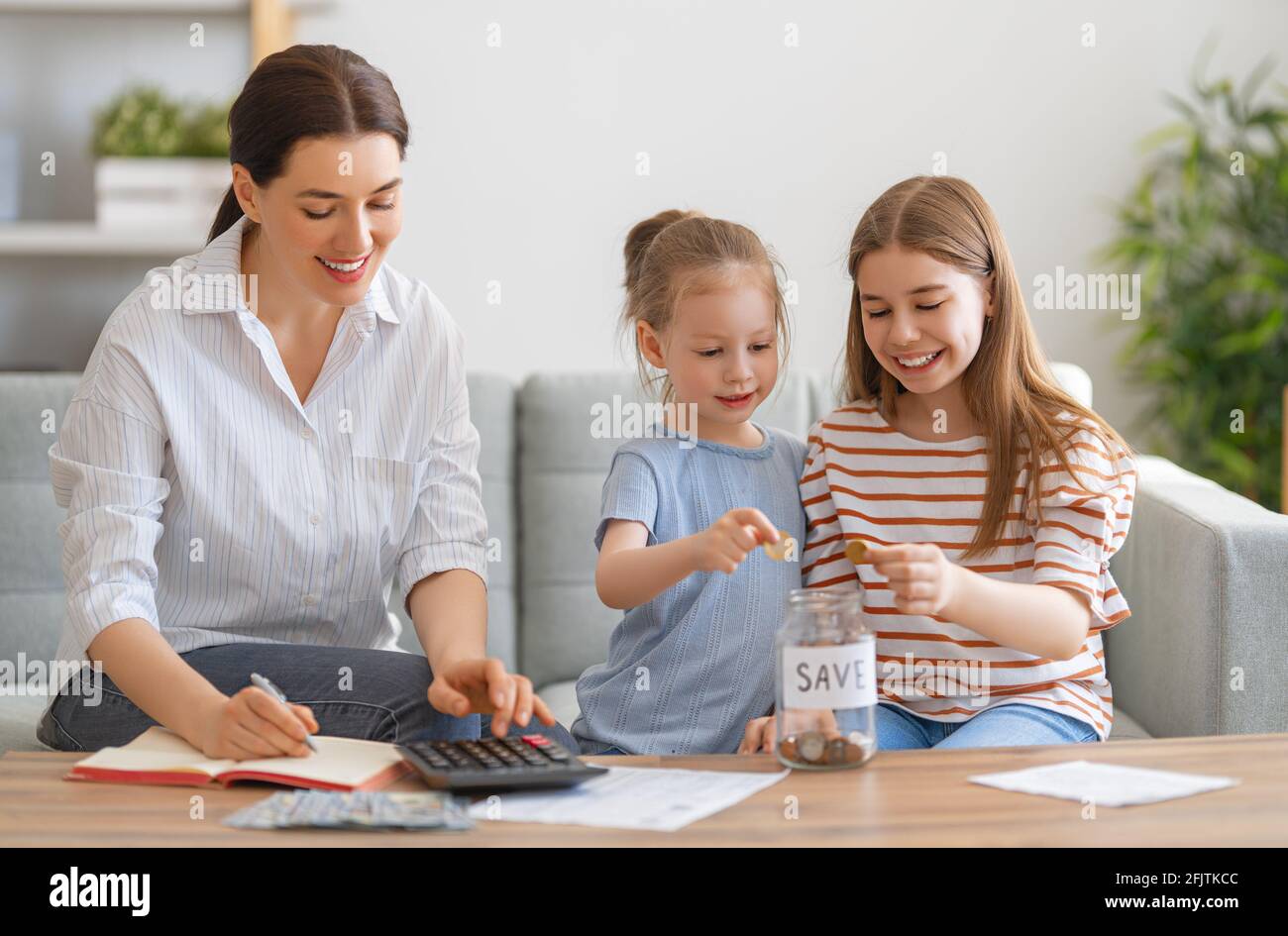 Woman and children are sitting on the sofa with a paper receipt ...